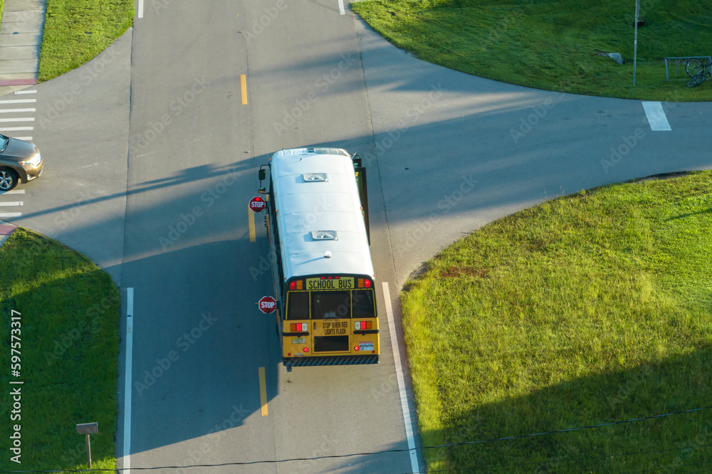 Top view of standard american yellow school bus picking up kids at ...