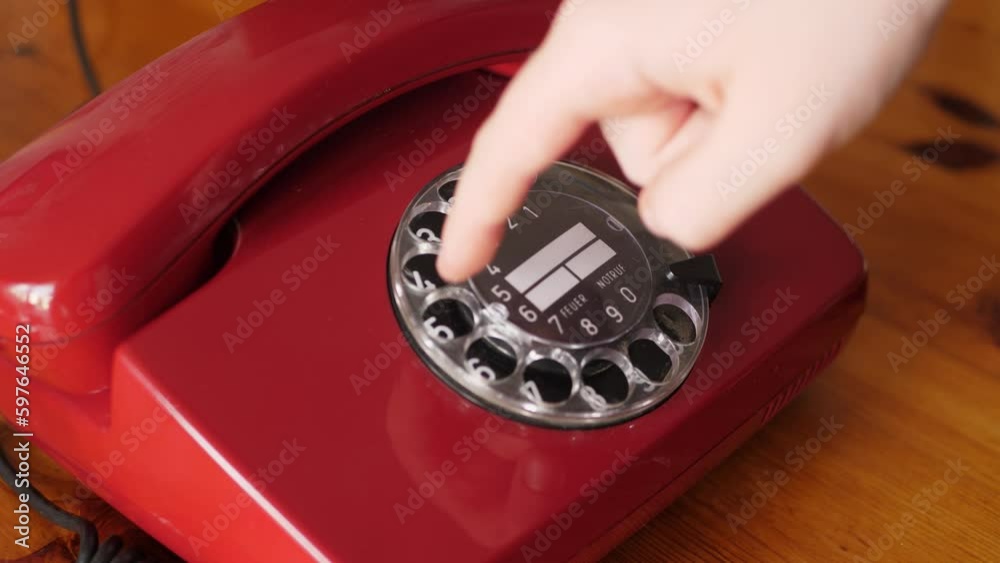 Modern child attempting to operate rotary dial phone with fingers ...