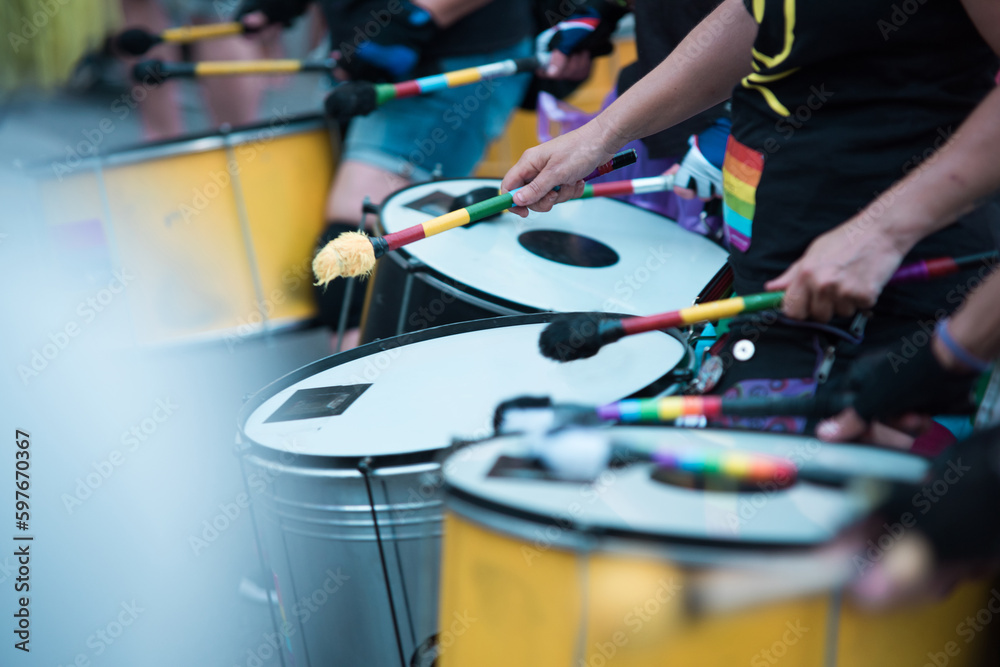 Colorful drum band playing drums in the street at a public event during ...
