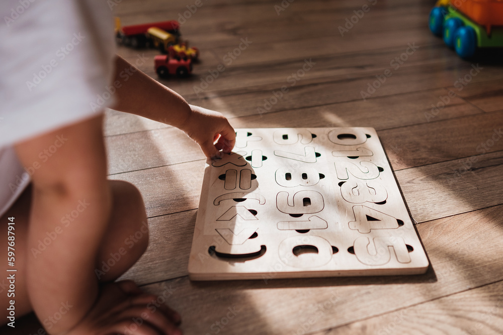 Little child learning numbers with wooden counting puzzle peg board ...