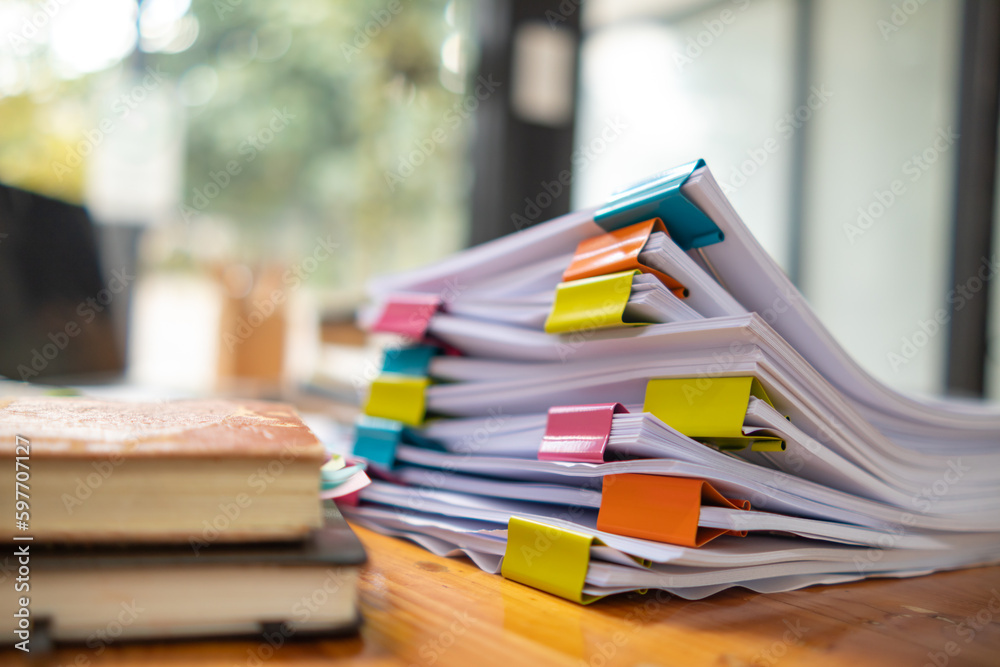 Businesswoman hands working on stacks of paper documents to search and review documents piled on ...