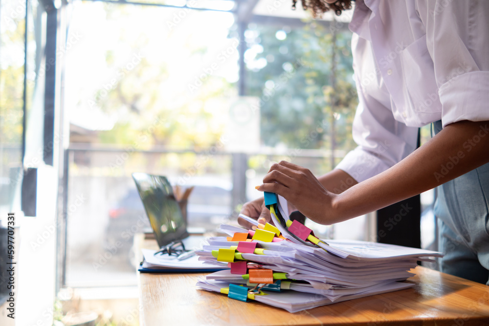 Businesswoman hands working on stacks of paper documents to search and ...