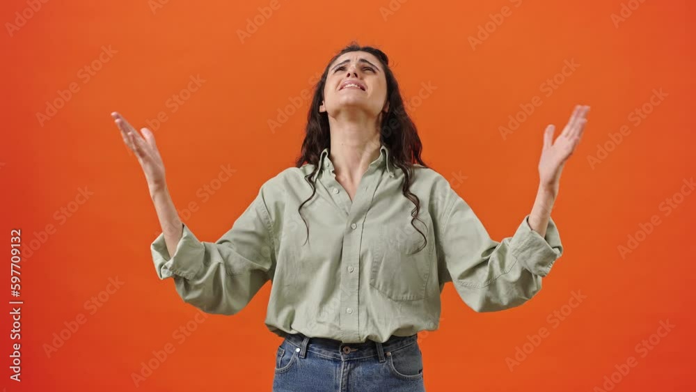 Helpless young Caucasian woman raising arms up, asking for help making ...