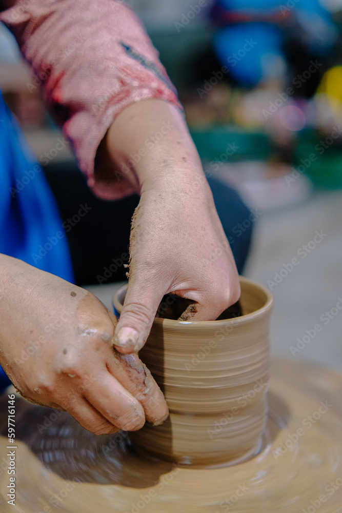 A potter skillfully creates works of art from clay on the potter's ...