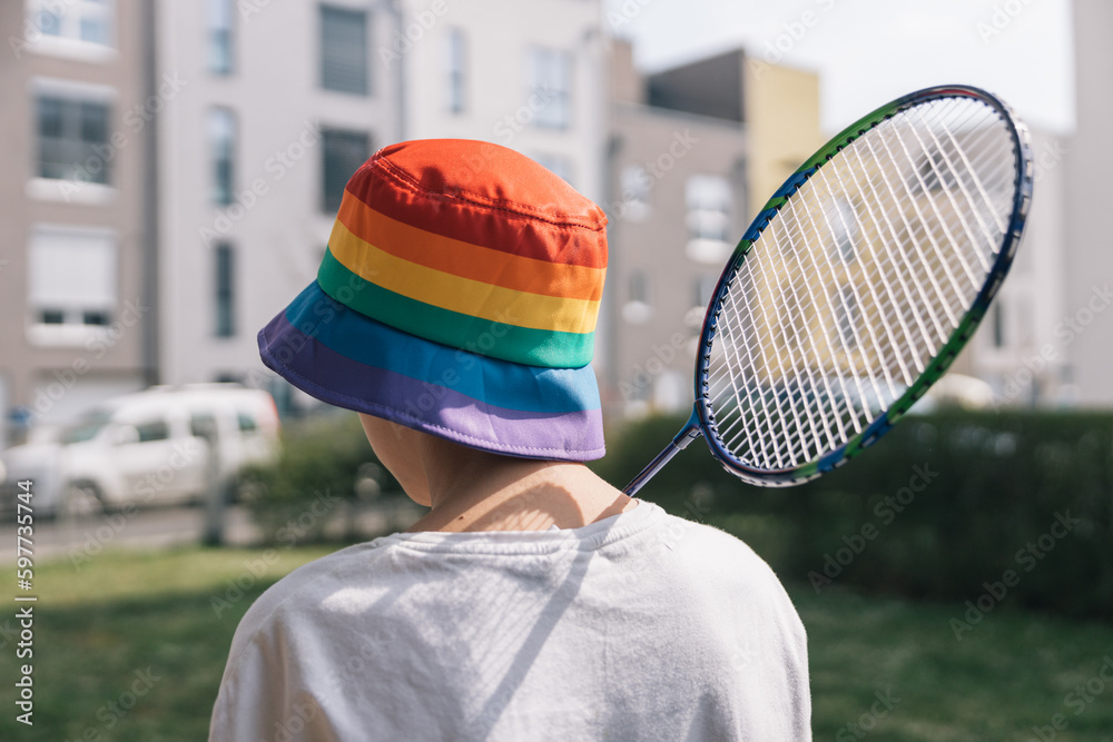 Teenage with a rainbow hat and a badminton racket on her shoulder Stock ...