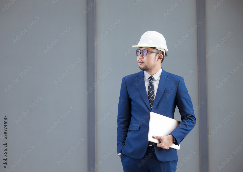 Handsome engineer wearing suit and hard hat or white helmet on building ...