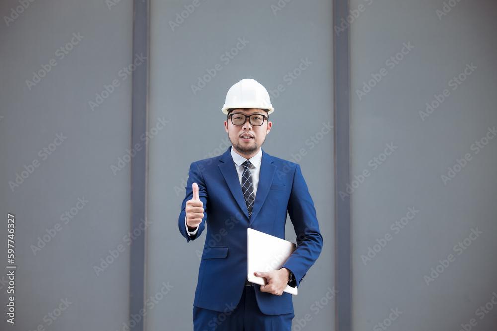 Handsome engineer wearing suit and hard hat or white helmet on building ...