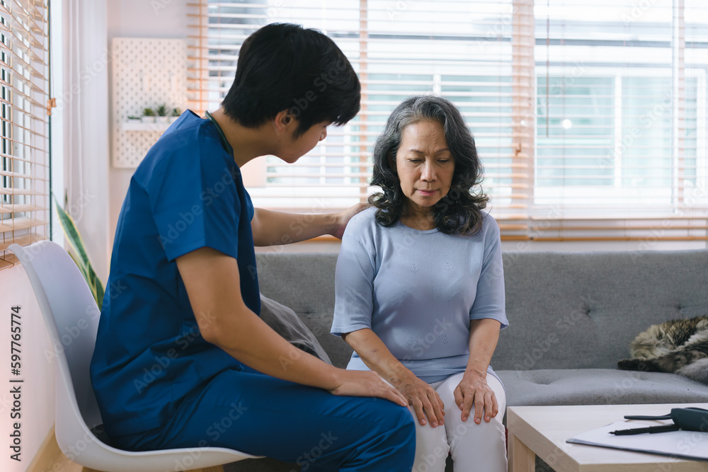 A young caregiver is consulting with a 60-year-old Asian elderly woman ...