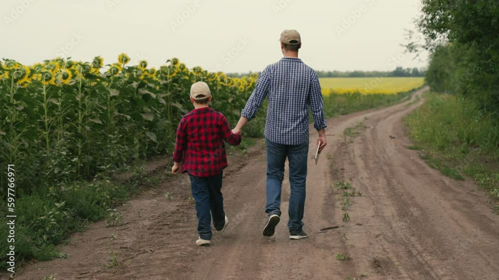 Agriculture. the boy walks along the road with his father by the hand ...