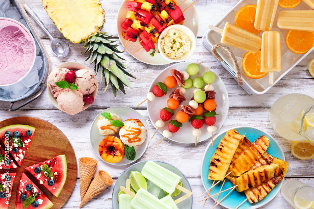 Refreshing summer food table scene. Assortment of grilled fruits, ice ...