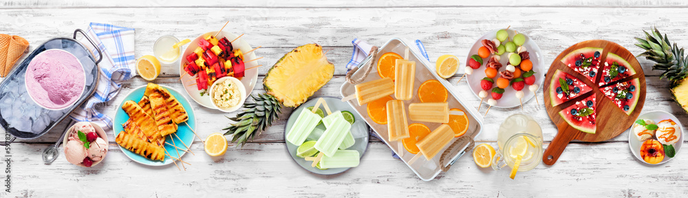 Refreshing summer food table scene. Assorted grilled fruits, ice cream ...