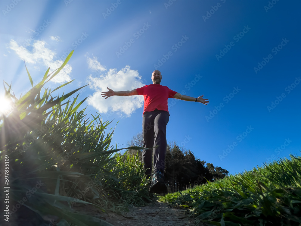 Running Man in full nature with a bottom up view Stock Photo | Adobe Stock