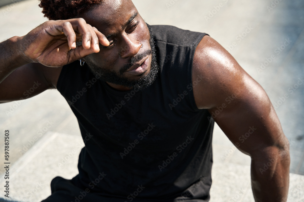 Fit sporty young African man wearing black sportswear relaxing after ...
