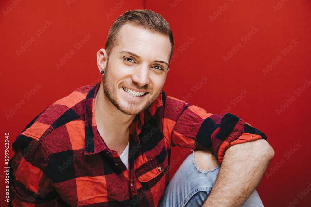 nonchalant guy sit with elbow to knee and arm on his leg while look at ...