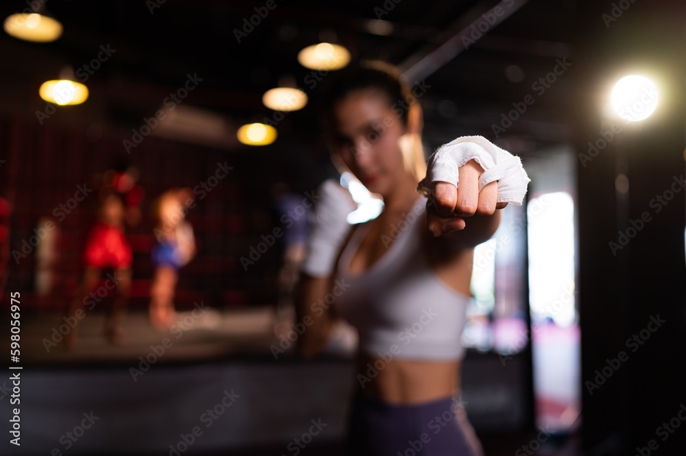 Portrait of woman learning Muay Thai to build up the strength of the ...