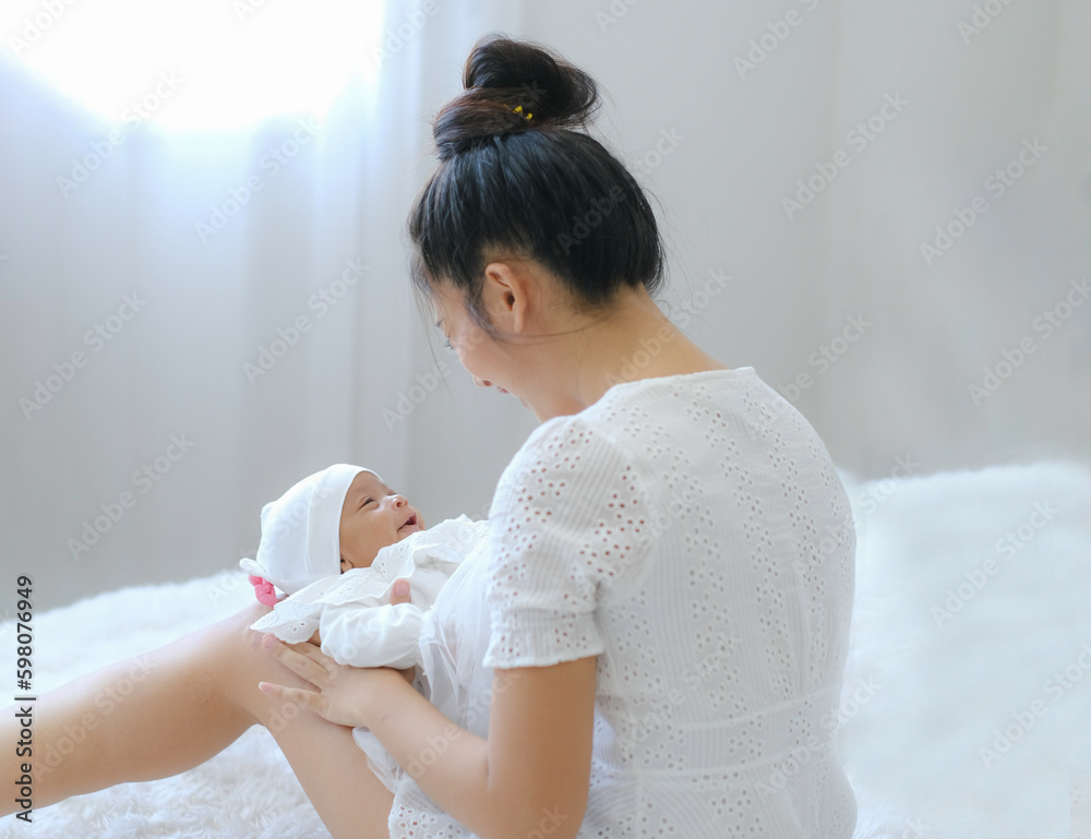 Happy baby with cute smile sleep on her mother's lap and play with her ...