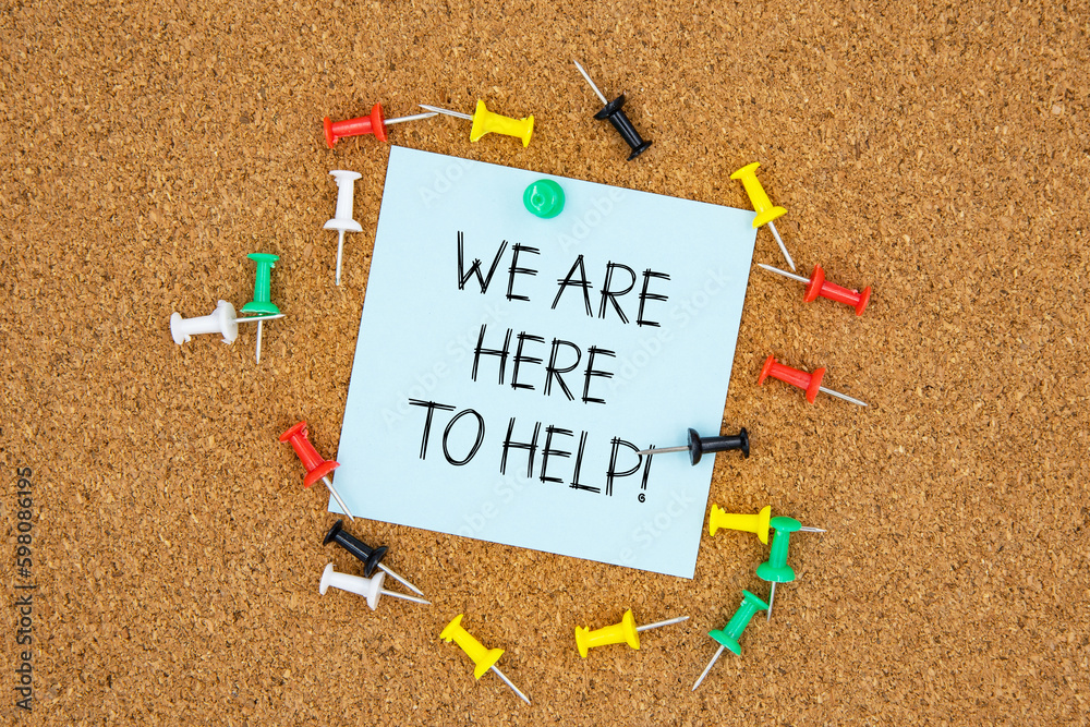 We are here to help text on light blue post-it paper pinned on bulletin ...