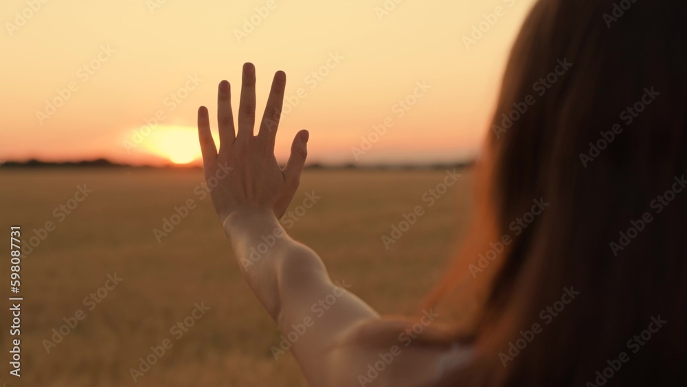 Happy girl stretches her hand to yellow sunset. Sun between fingers of ...
