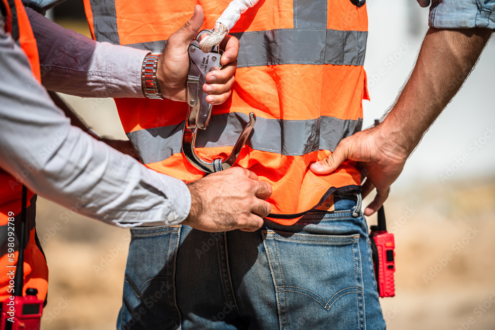 Construction worker men wearing safety sling climbing belt and hardhat ...