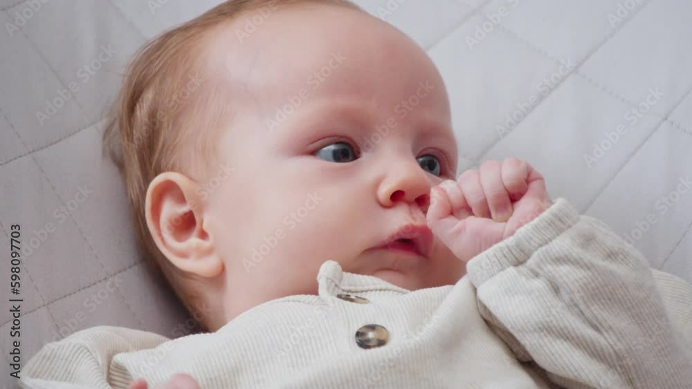 Close-up view of newborn adorable baby girl with big gray eyes and tiny ...