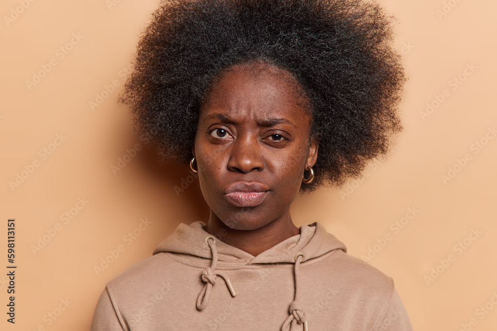 Headshot of beautiful African American woman looks with suspicion ...