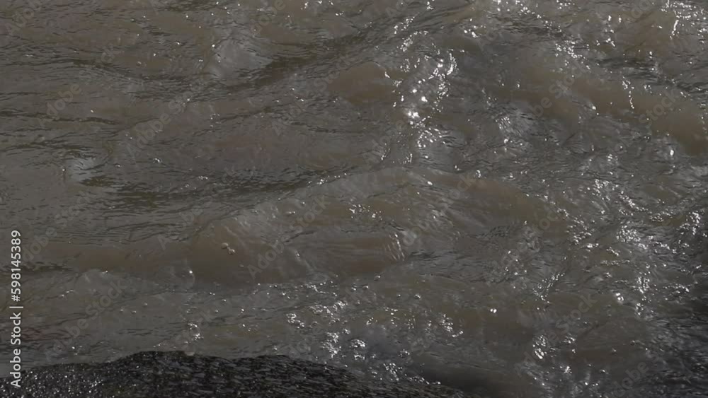 A stream of sea salt water is splashing over broken walls and muddy ...