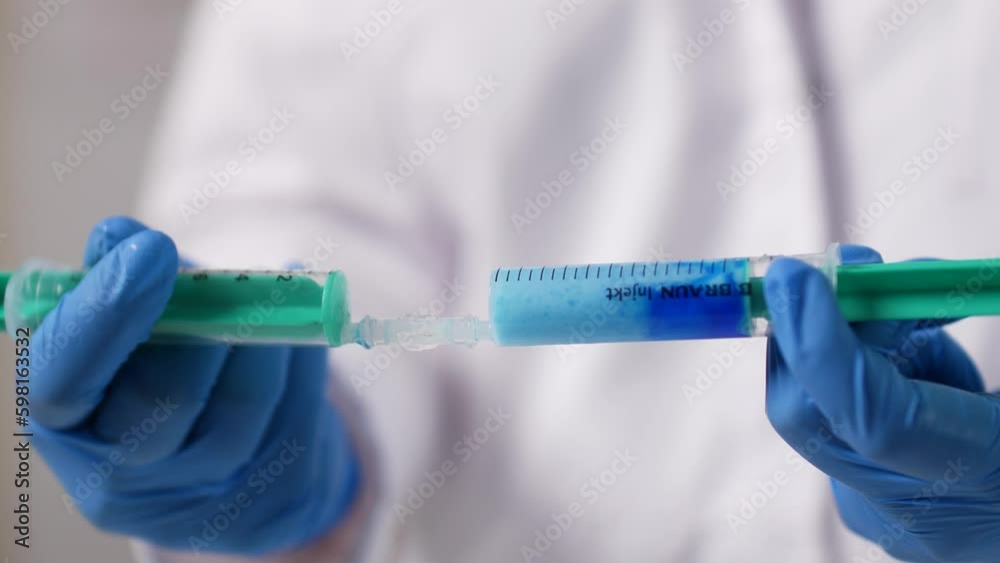 Two syringes push a liquid back and forth with a cream liquide inside ...