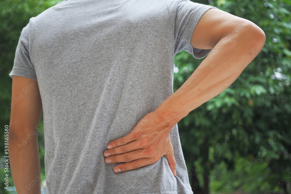 man holding her lower back while and suffer from unbearable pain health ...