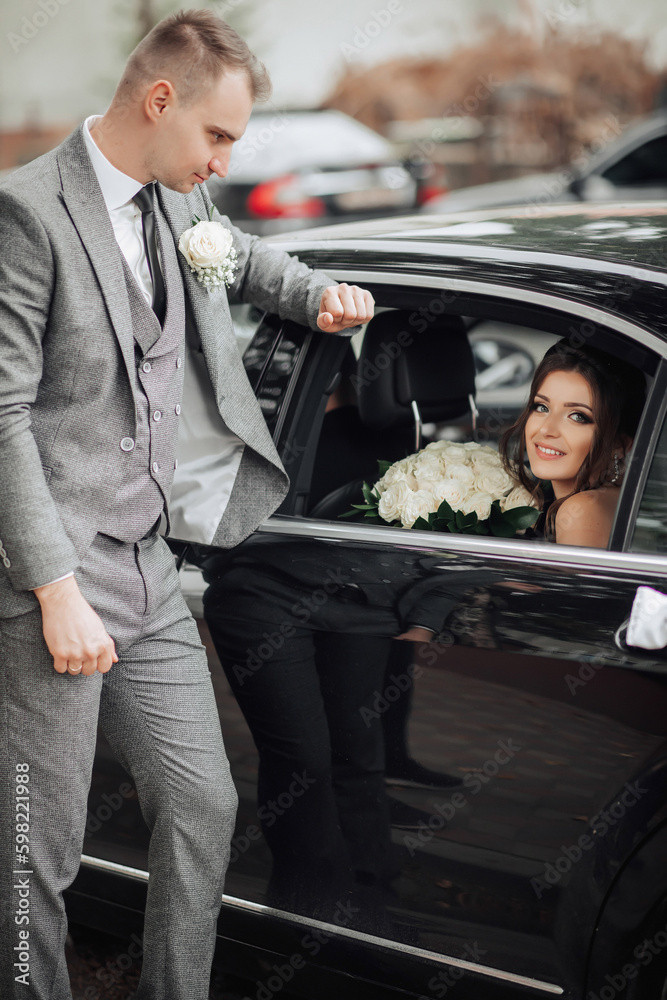 Wedding photo. The bride with a bouquet of roses sits smiling in a ...