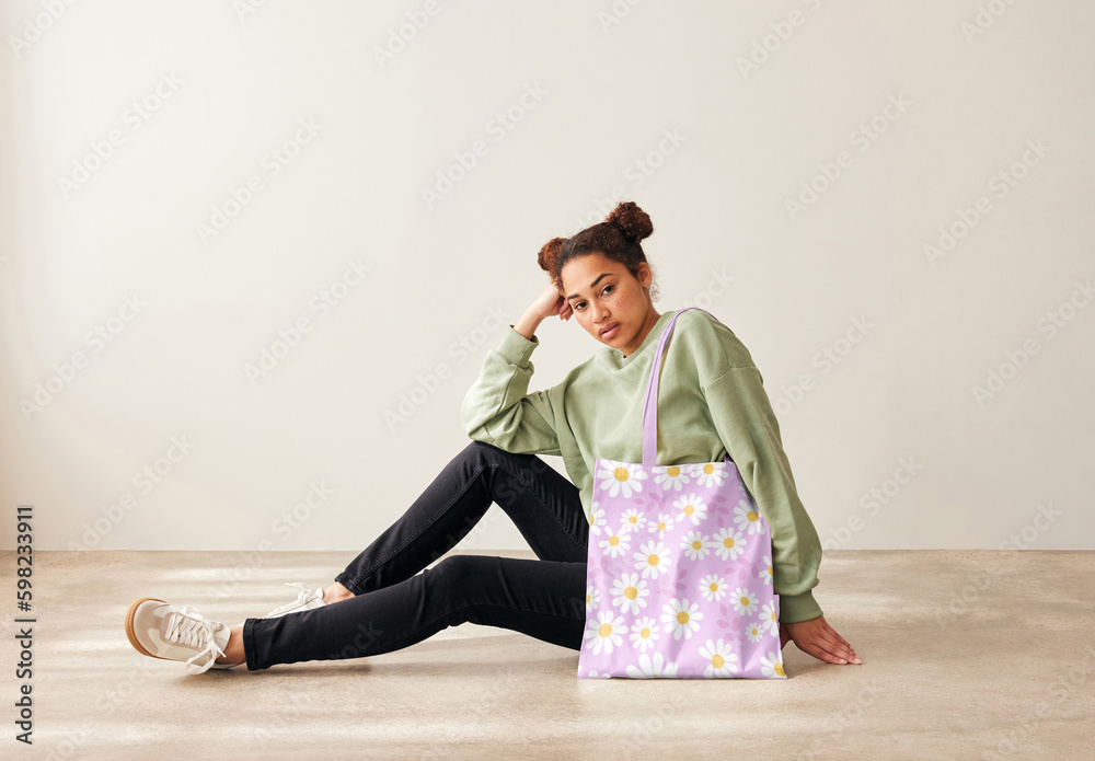 Mockup of customizable tote bag being modelled by woman sitting on ...