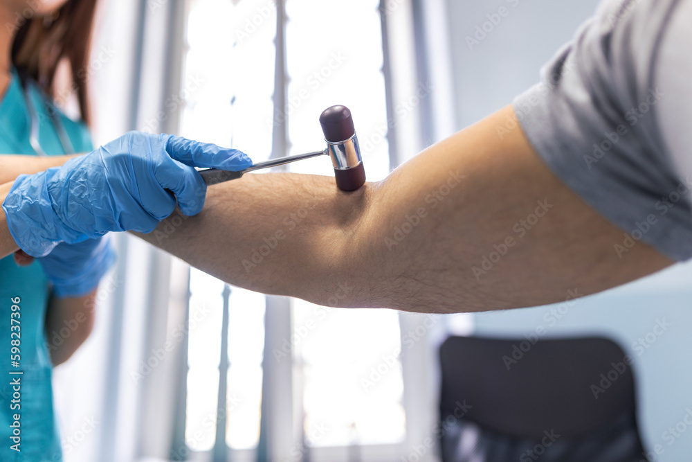 Neurological examination. The neurologist testing reflexes on a male ...