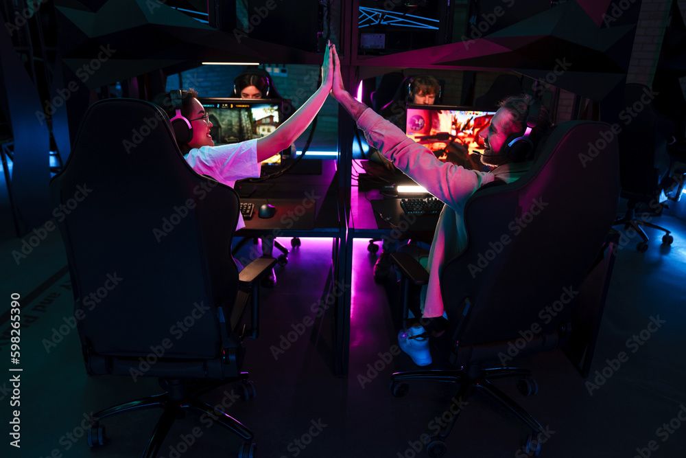 Gamers giving high five to each other while playing online game on ...