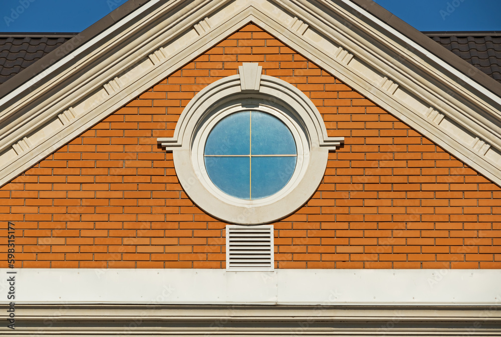 Round window in a red brick wall on facade of a modern house ...