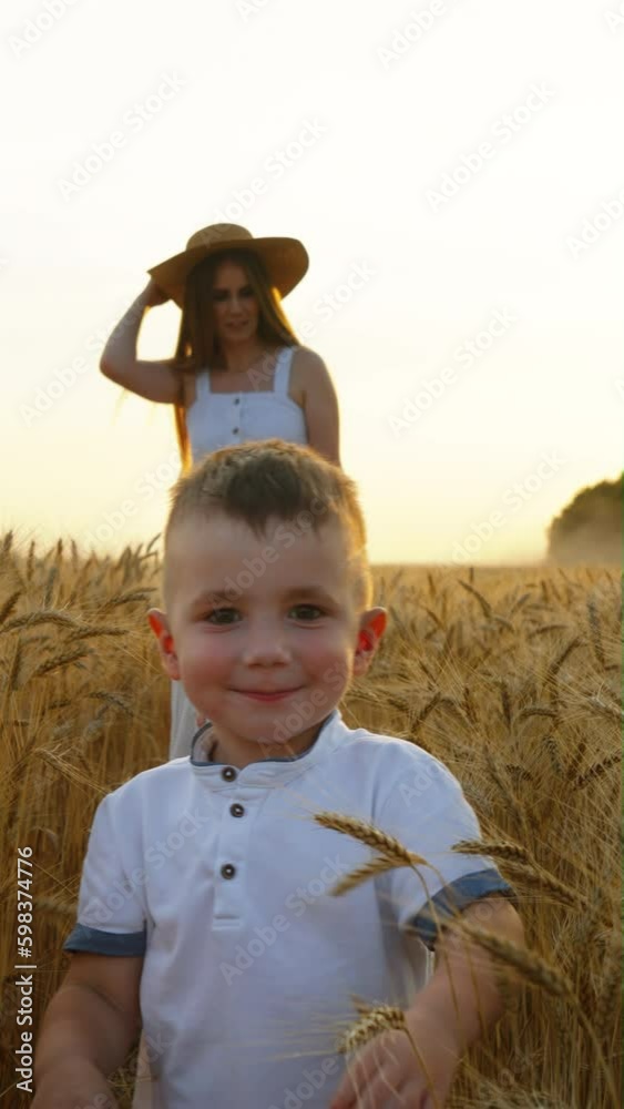 Vertical Screen: Little boy in summer clothes walking among wheat crops ...