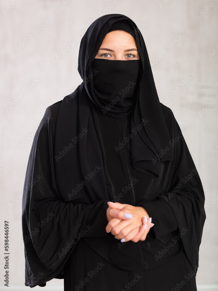 young light-skinned Muslim woman with kind eyes and face covered with ...