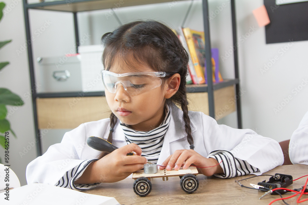 School student making robotic cars. Girl at robotics school makes robot ...
