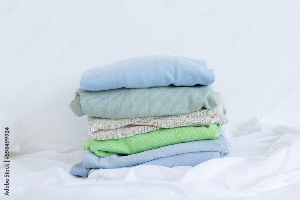Pile of clothes on white, pastel color palette of stacked sweaters and ...
