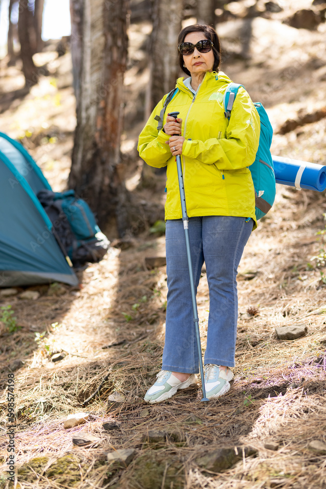 Beautiful senior women in early 60 hiking in forest, sightseeing and ...