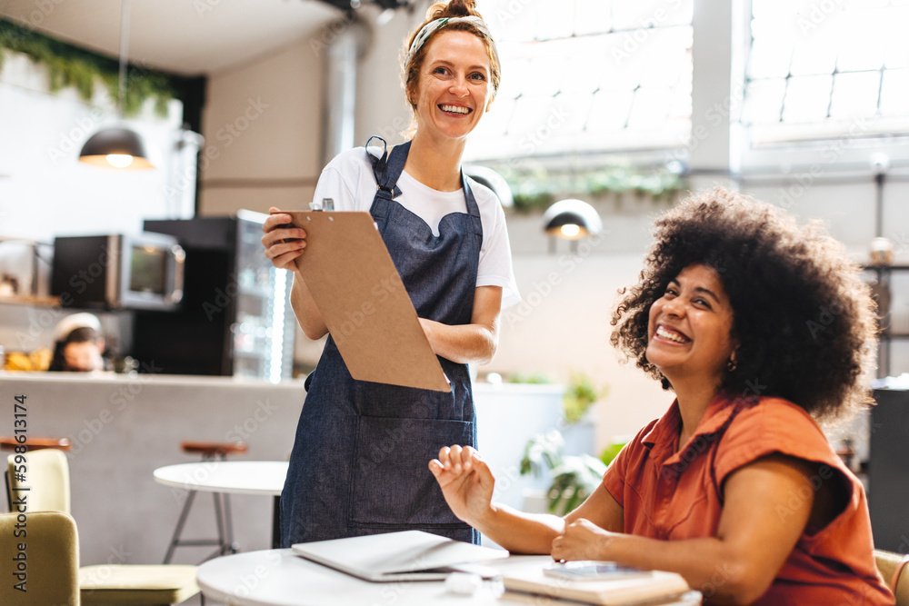 Happy waitress serving a customer with the menu in a cafe Stock Photo ...