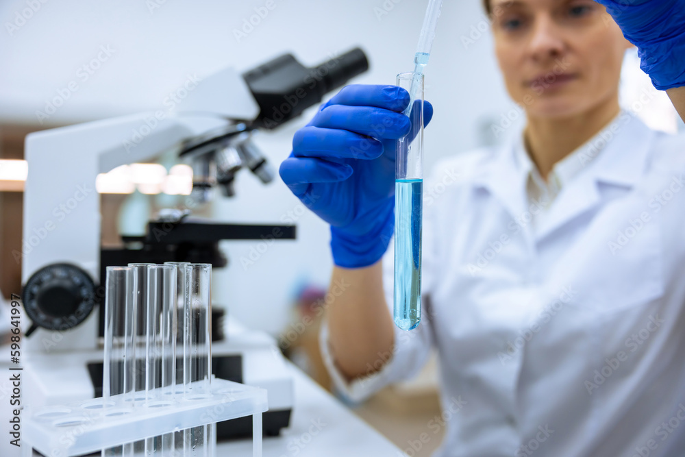 Woman in white medical or chemistry laboratory, working at lab with ...