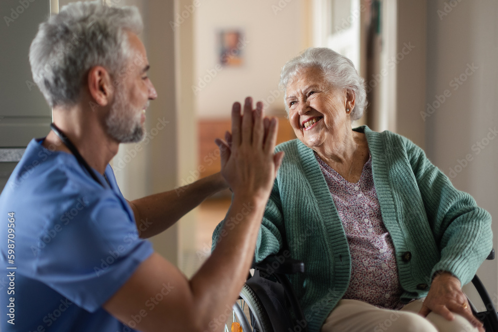 Caregiver spending time with his senior woman client at her home. Stock ...