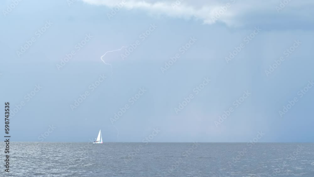 Vidéo Stock Rain on the horizon, gray rain clouds and white sailboat ...