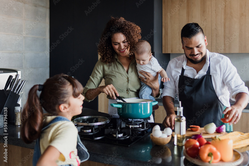 latin family cooking together with children daughter and son in kitchen ...