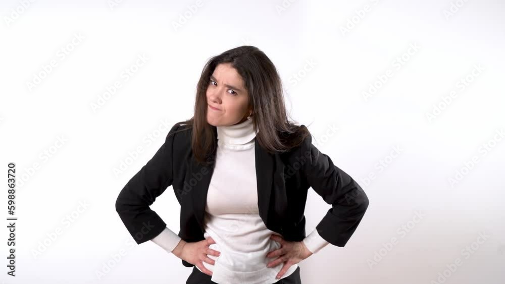 Elegantly dressed angry young woman with long dark hair against white ...