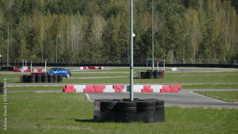 Stockvideo Sporty blue coupe passes by on small private race track with ...