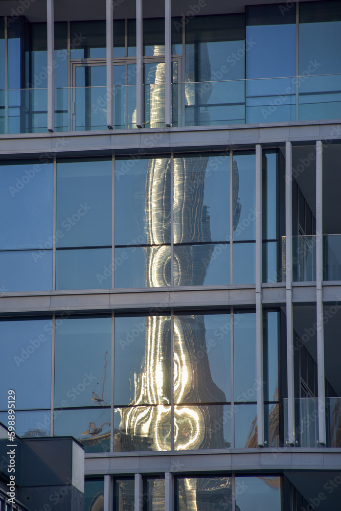 The reflection of the Burj Khalifa on a building glass in Dubai City ...