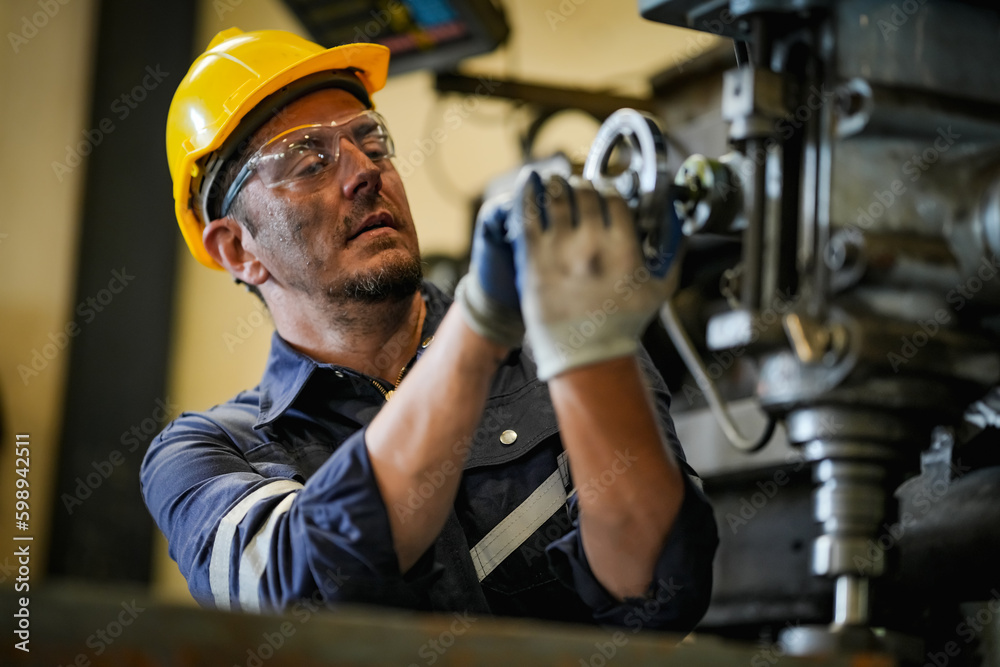 Lathe Operators Concentrated on Work. Worker in uniform and helmet works on lathe, factory ...