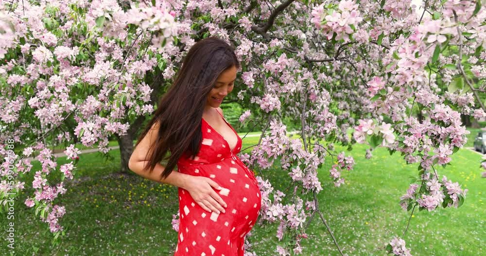 Pregnant woman happy portrait in with spring flowers. New season and ...