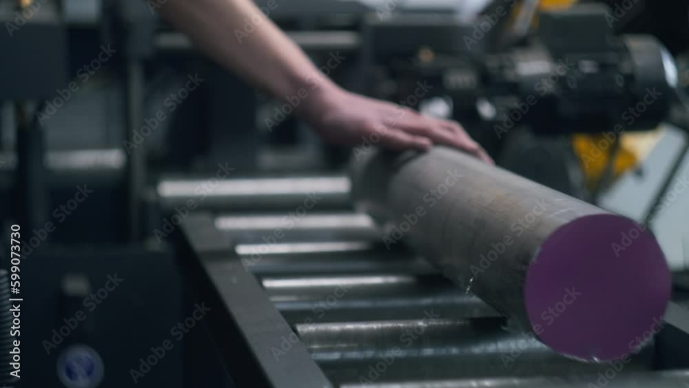 Experienced workman puts down metal bar on the desk with spinning ...