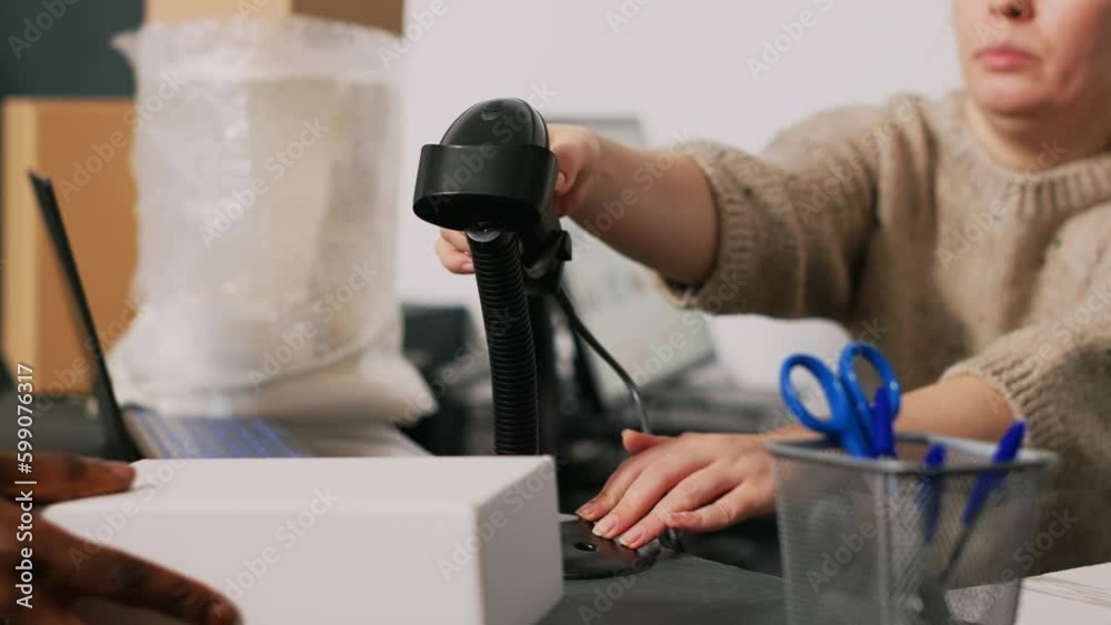 Two employees packing goods in boxes, preparing orders for retail store ...
